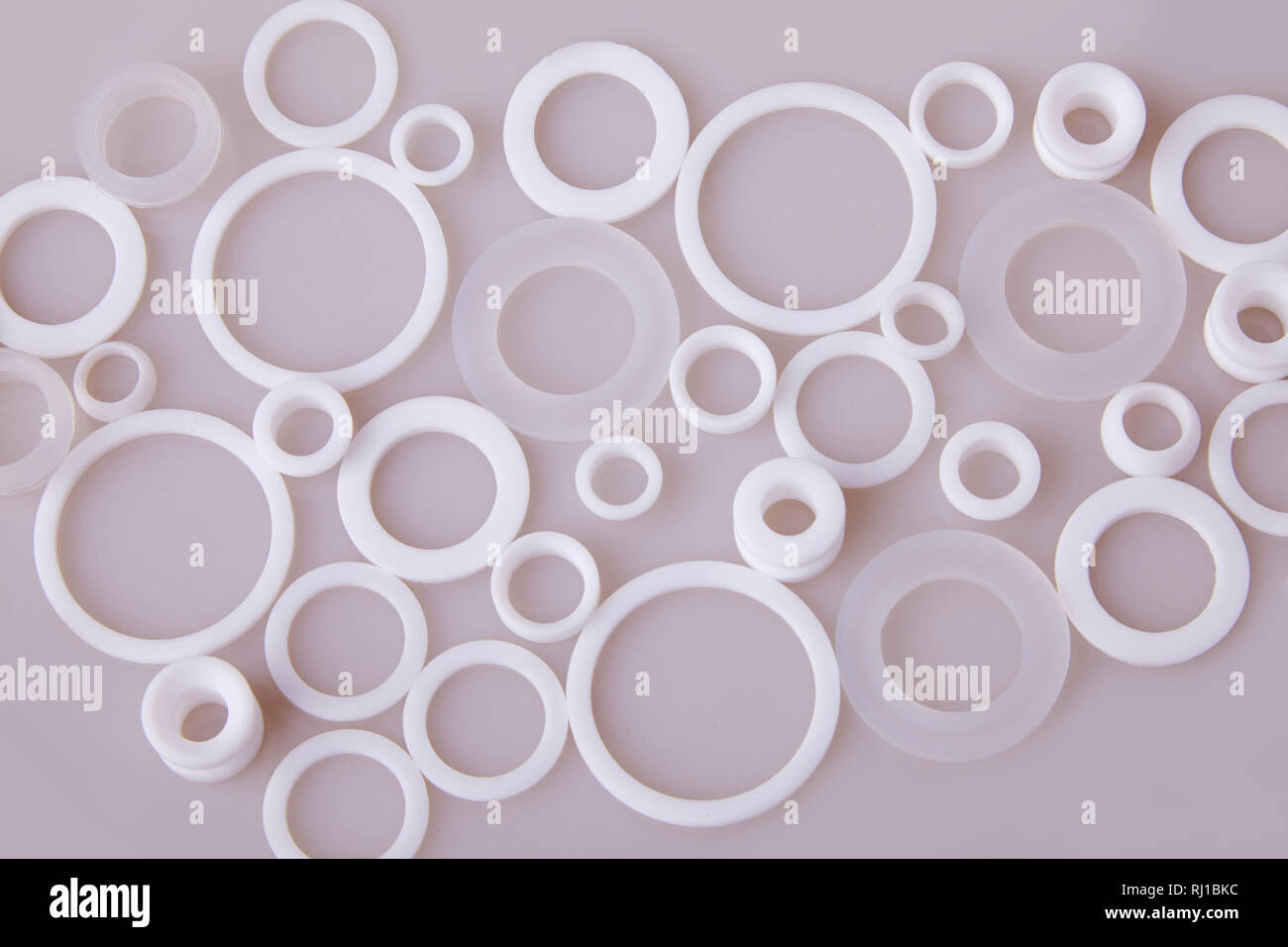 White hydraulic and pneumatic o-ring seals of different sizes scattered ...