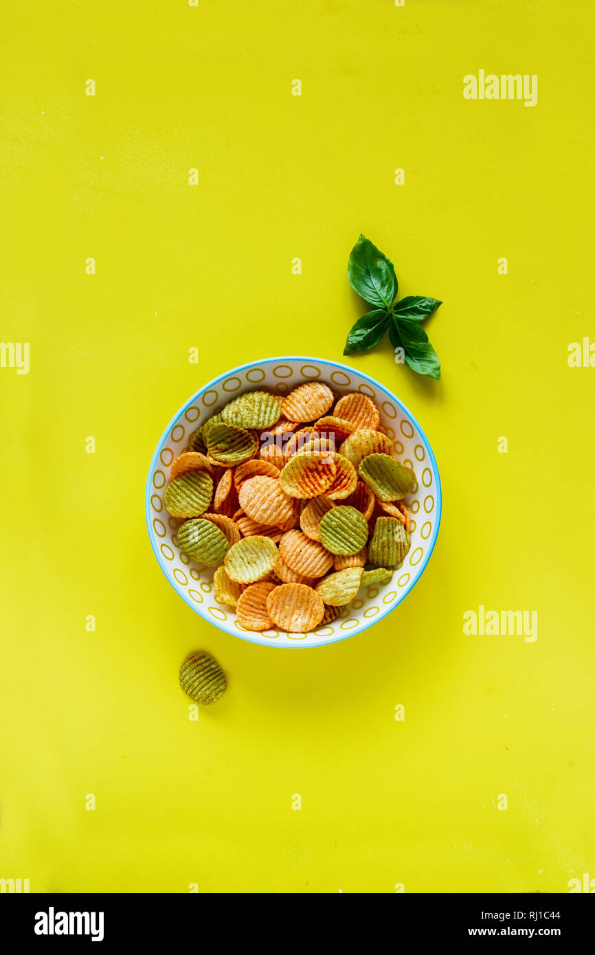 Flat lay of veggie chips on yellow background Stock Photo - Alamy