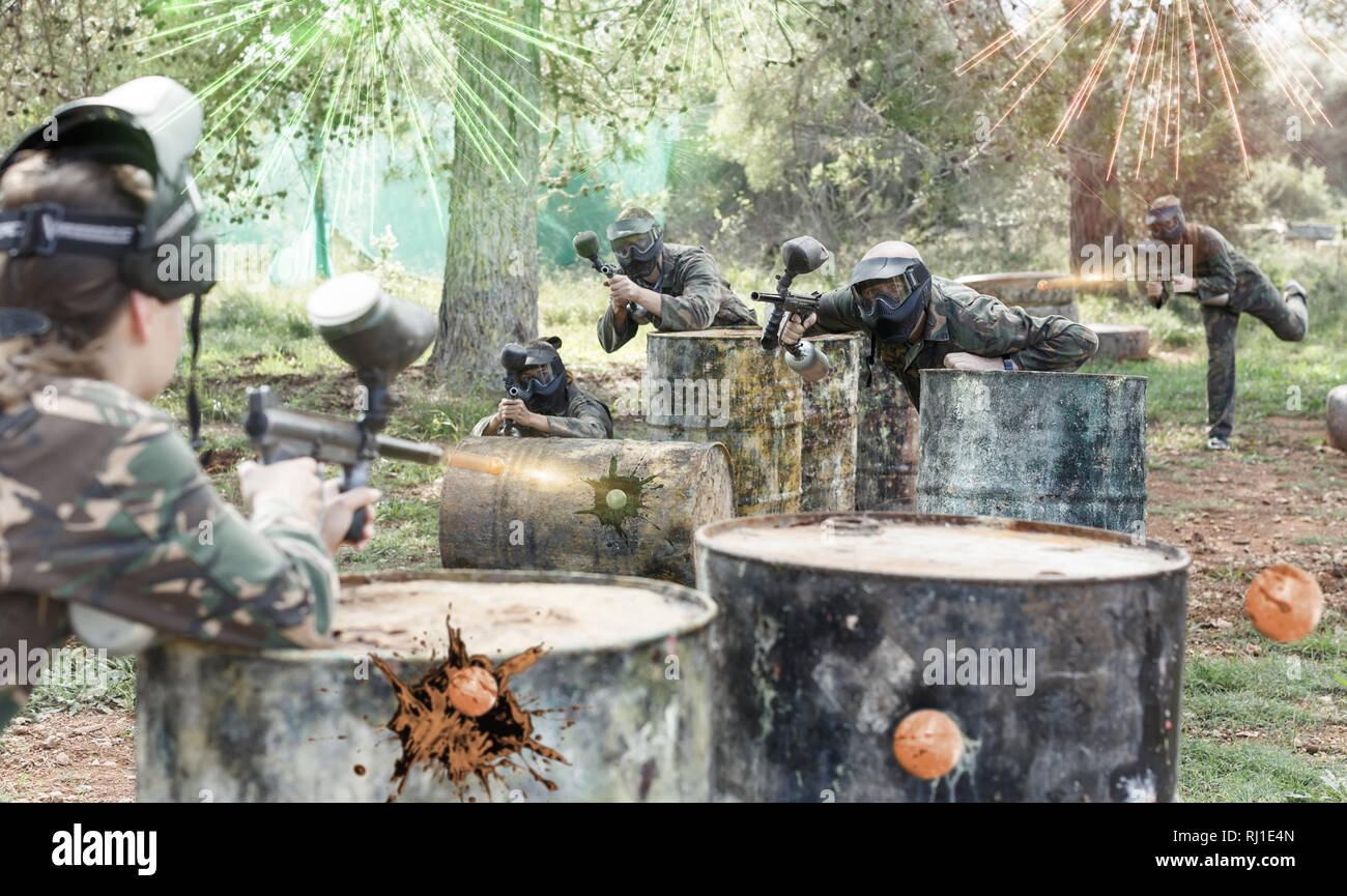 Two opposing teams in camouflage playing paintball against each other ...