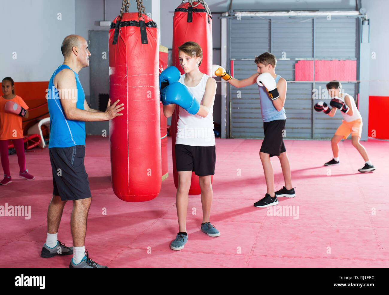 Teenagers boys posing in fighting stance at boxing gym with coach Stock ...