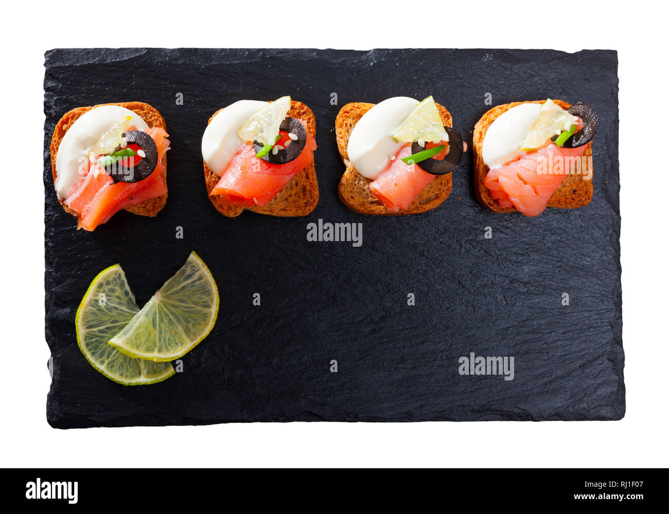 Top view of canapes on toasted bread with smoked salmon, olives and ...