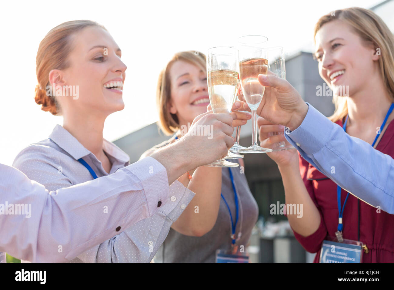 Business colleagues toasting wineglasses during success party on ...