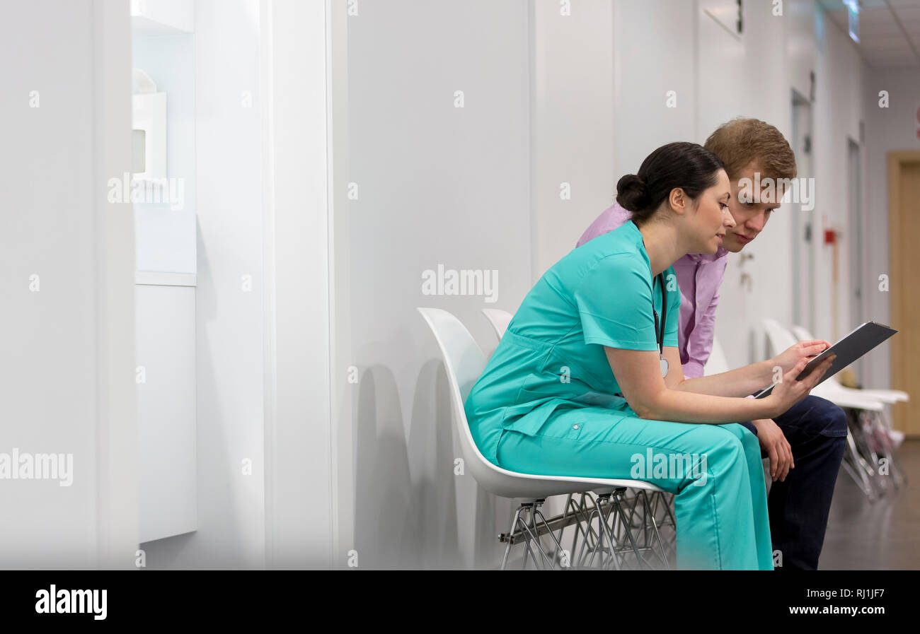 Nurse explaining medical form to young patient while sitting in ...