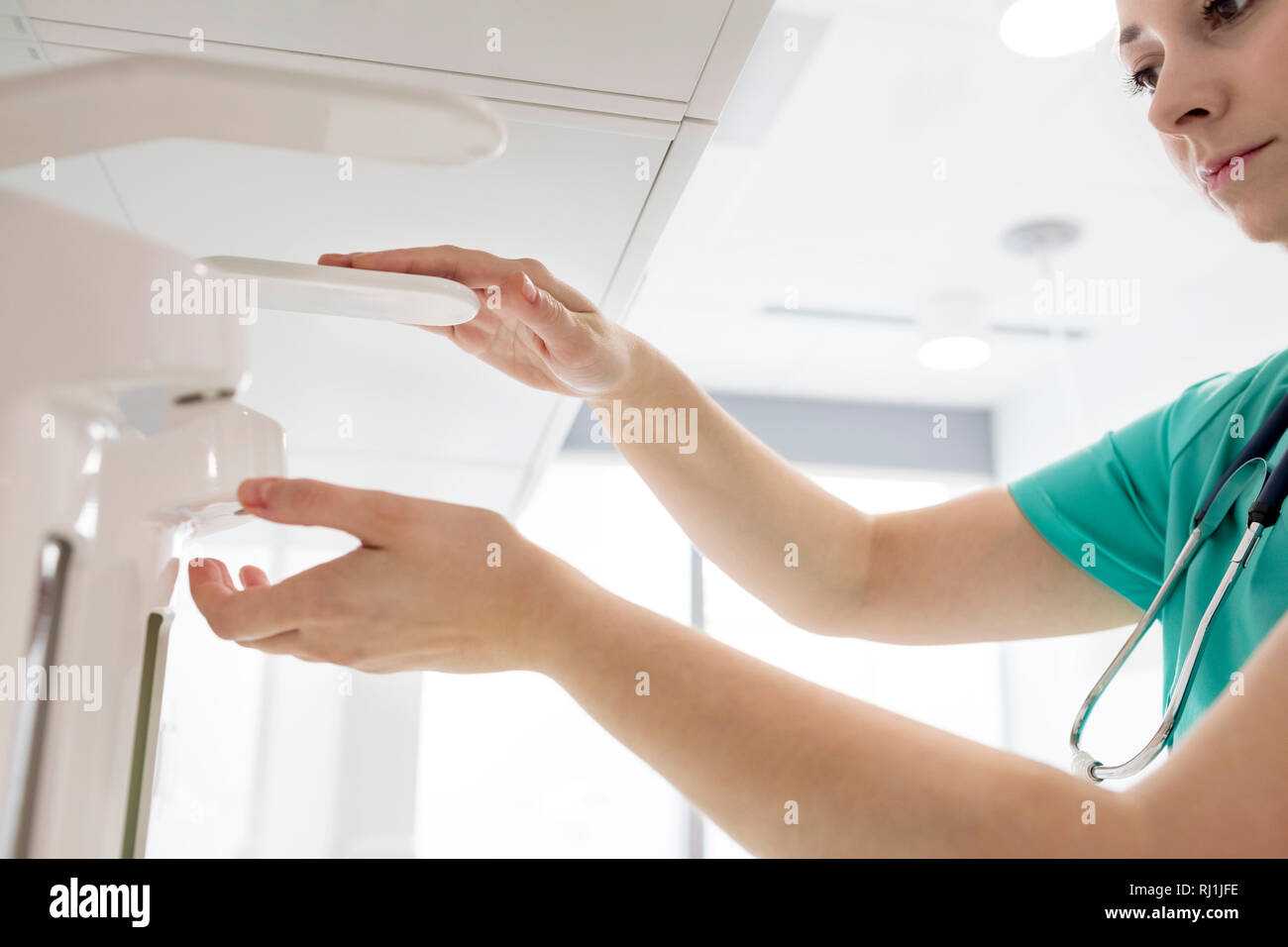 Doctor cleaning hands with anti-bacterial sanitizer dispenser in ...