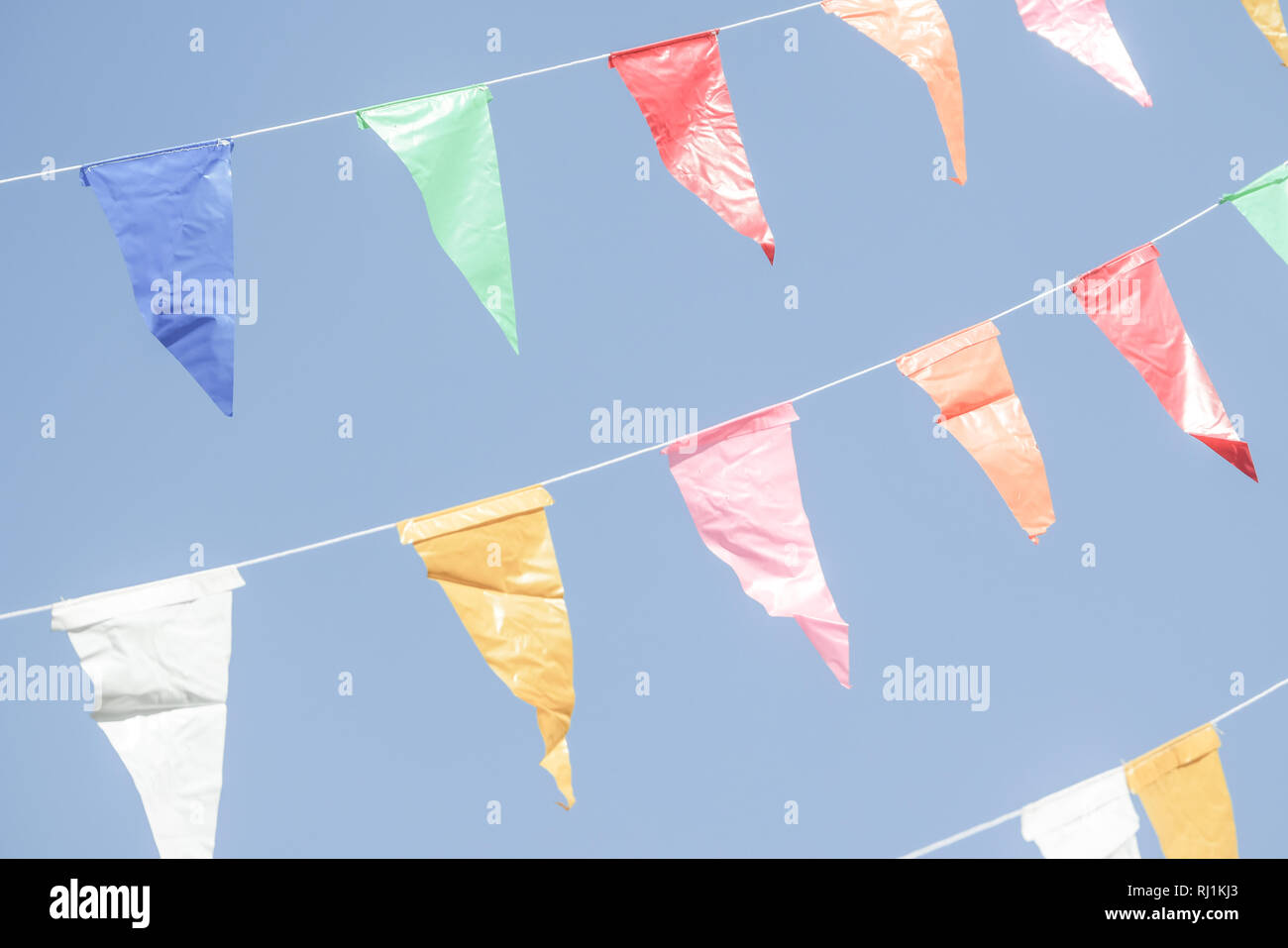 Colorful Party flags bunting hanging on blue sky for holiday decoration ...