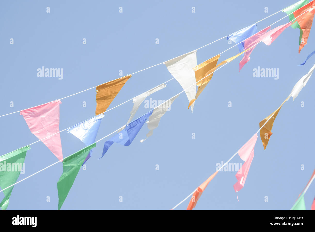 Colorful Party flags bunting hanging on blue sky for holiday decoration ...