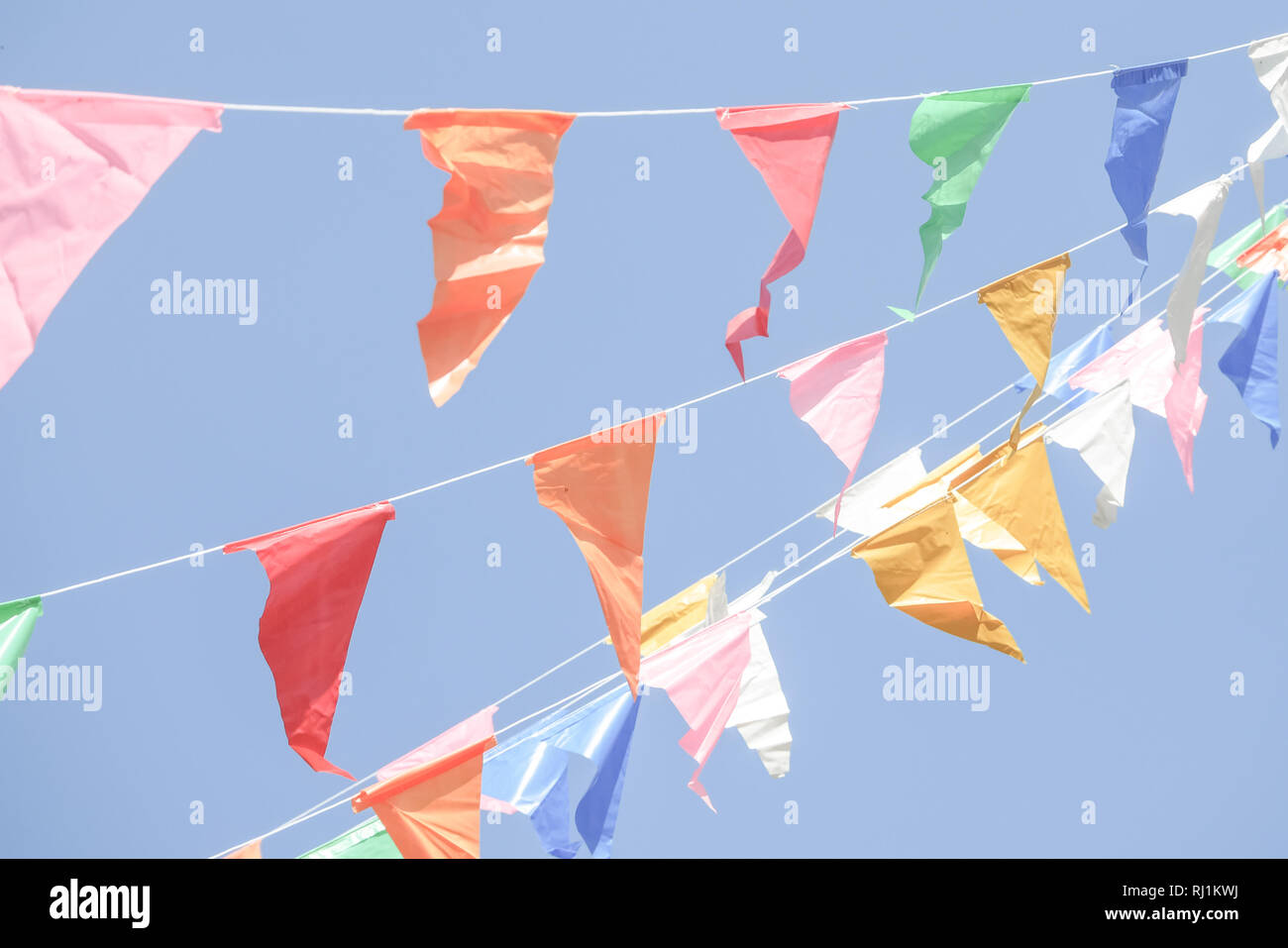 Colorful Party flags bunting hanging on blue sky for holiday decoration ...