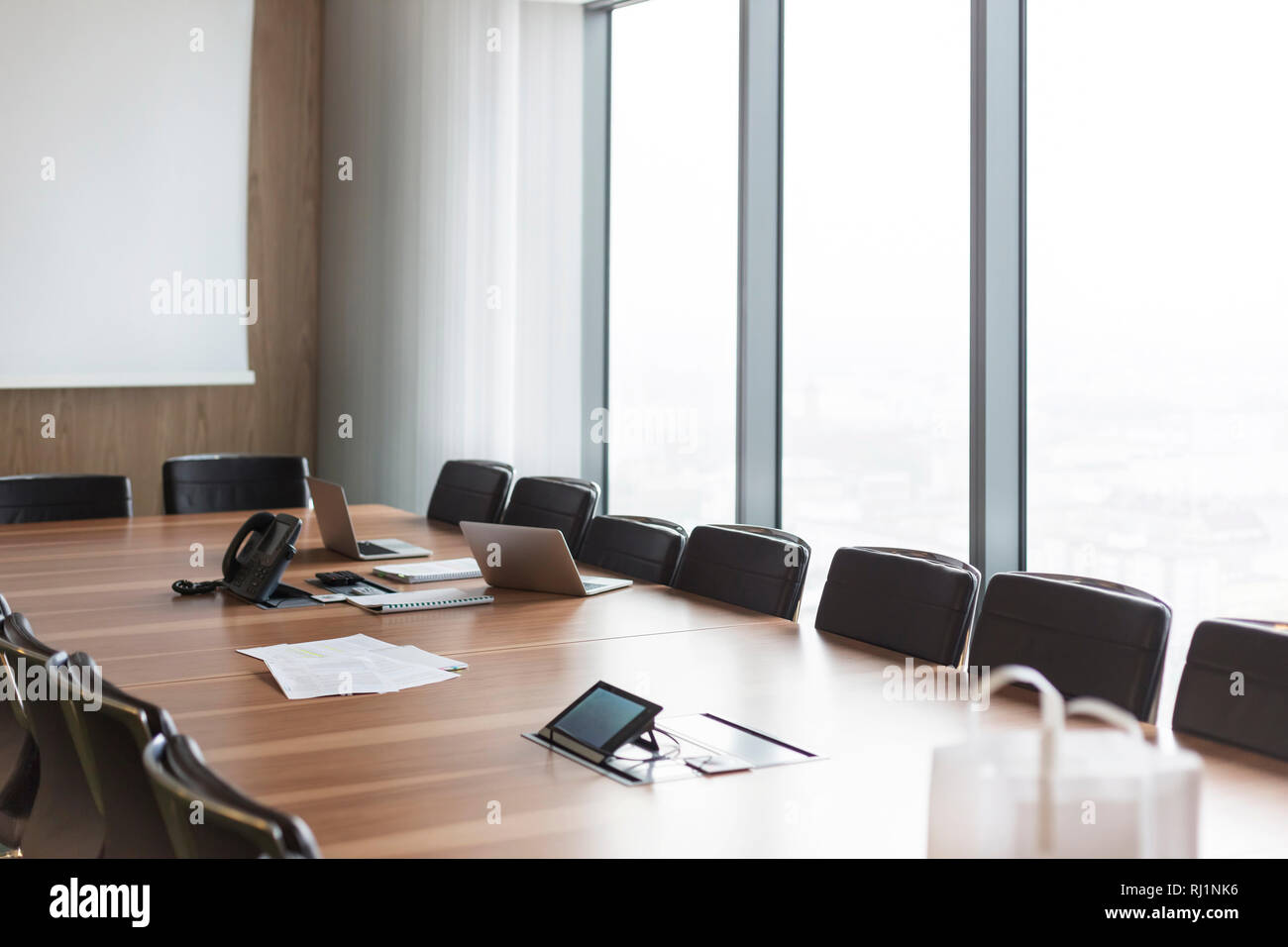 Documents with laptop and telephone on conference table in boardroom at ...