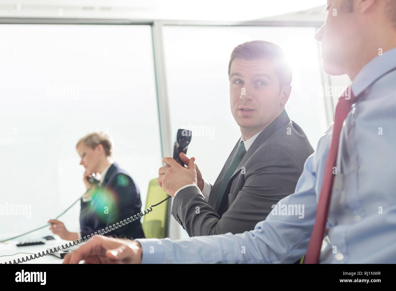 Businessmen talking while working at modern office Stock Photo - Alamy