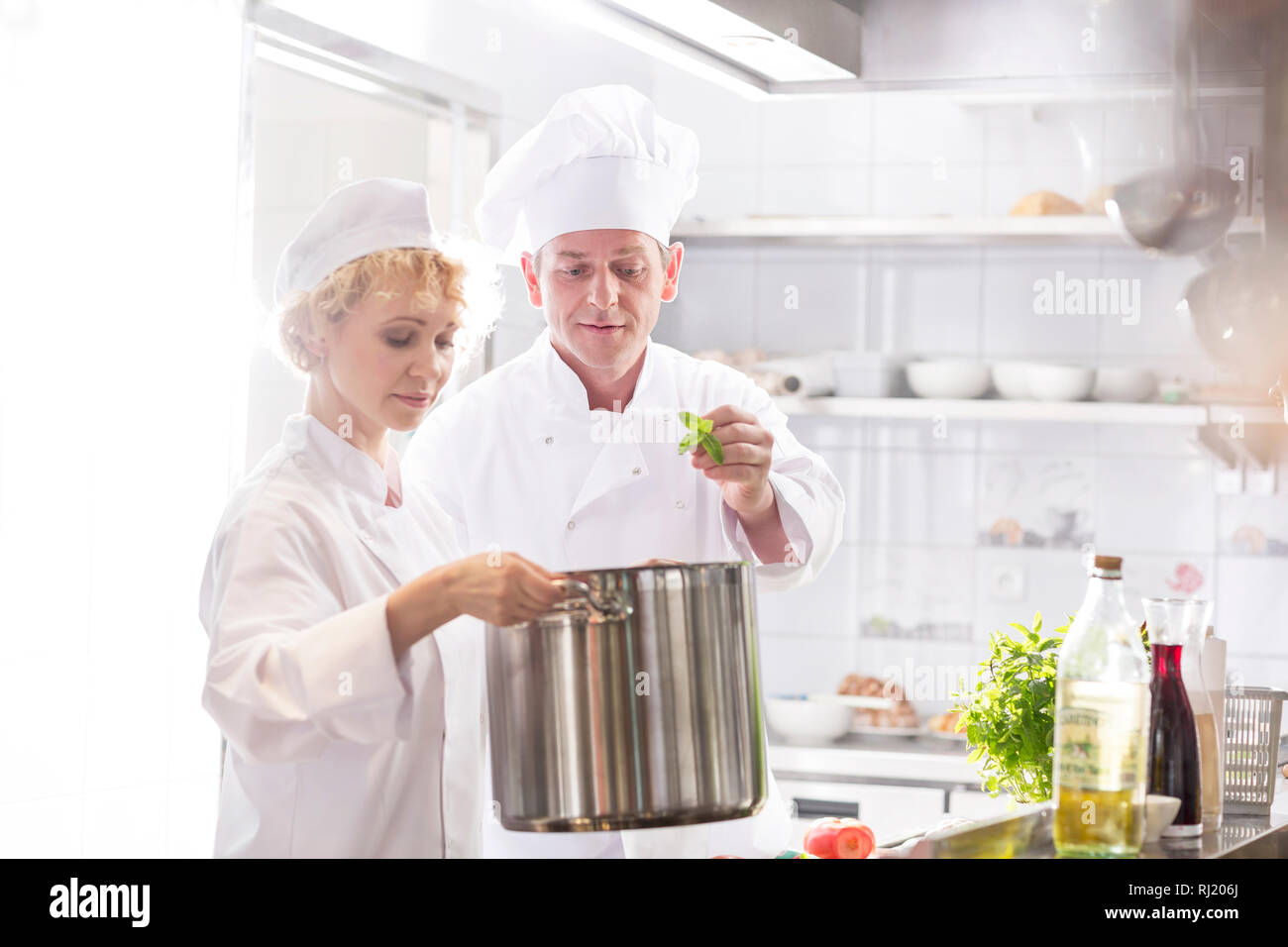 Mature chefs cooking in pot at restaurant kitchen Stock Photo - Alamy