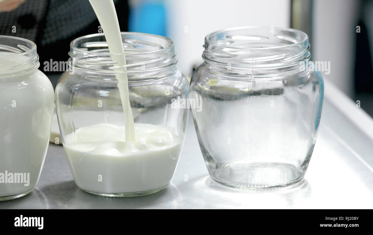 Close up glass jars filling with fresh milk Stock Photo - Alamy