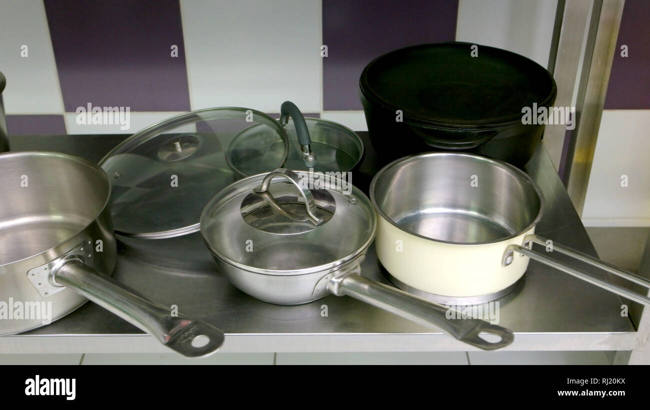 Stainless steel pans in the kitchen table Stock Photo - Alamy
