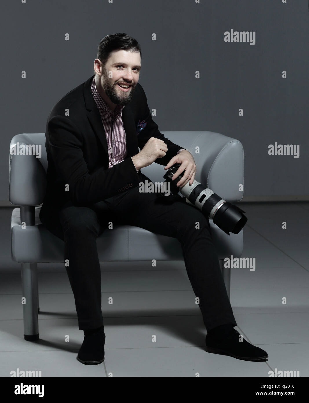 professional photographer sitting on an office chair.isolated on grey ...