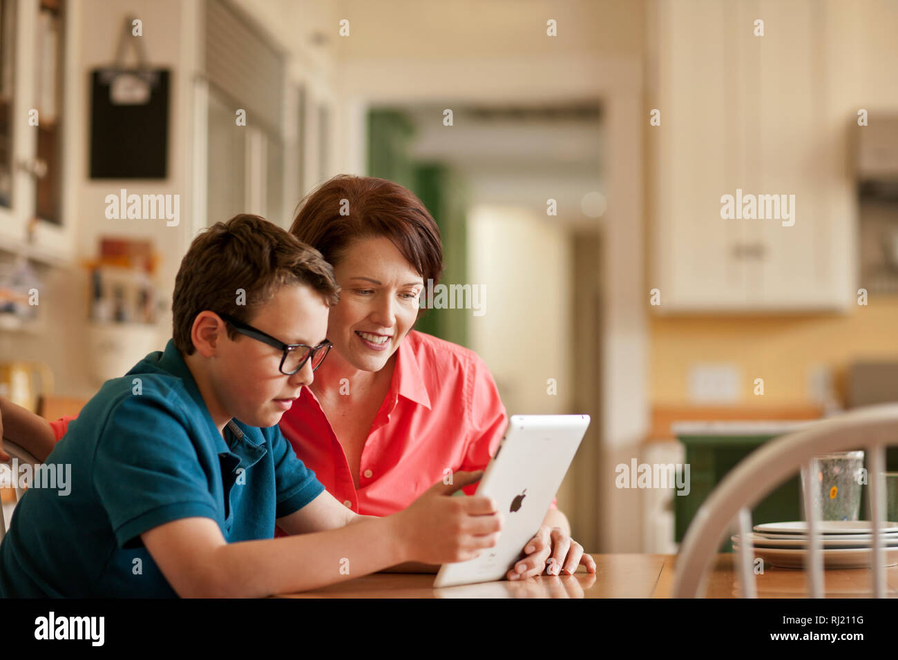 Teenage boy and his mother bonding over a digital tablet Stock Photo ...