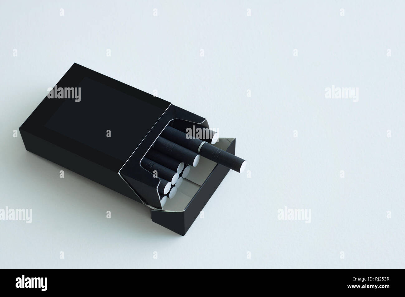 A black pack of cigarettes lies on a white background. Close-up Stock ...