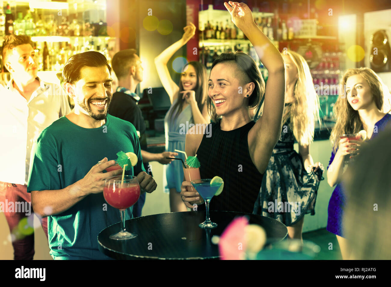 active male with female are talking and drinking cocktails on the party ...