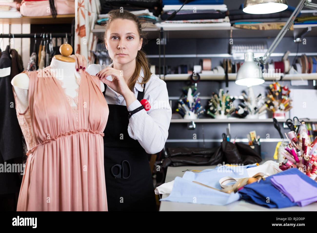 Portrait of woman designer who is standing on her workplace in time ...