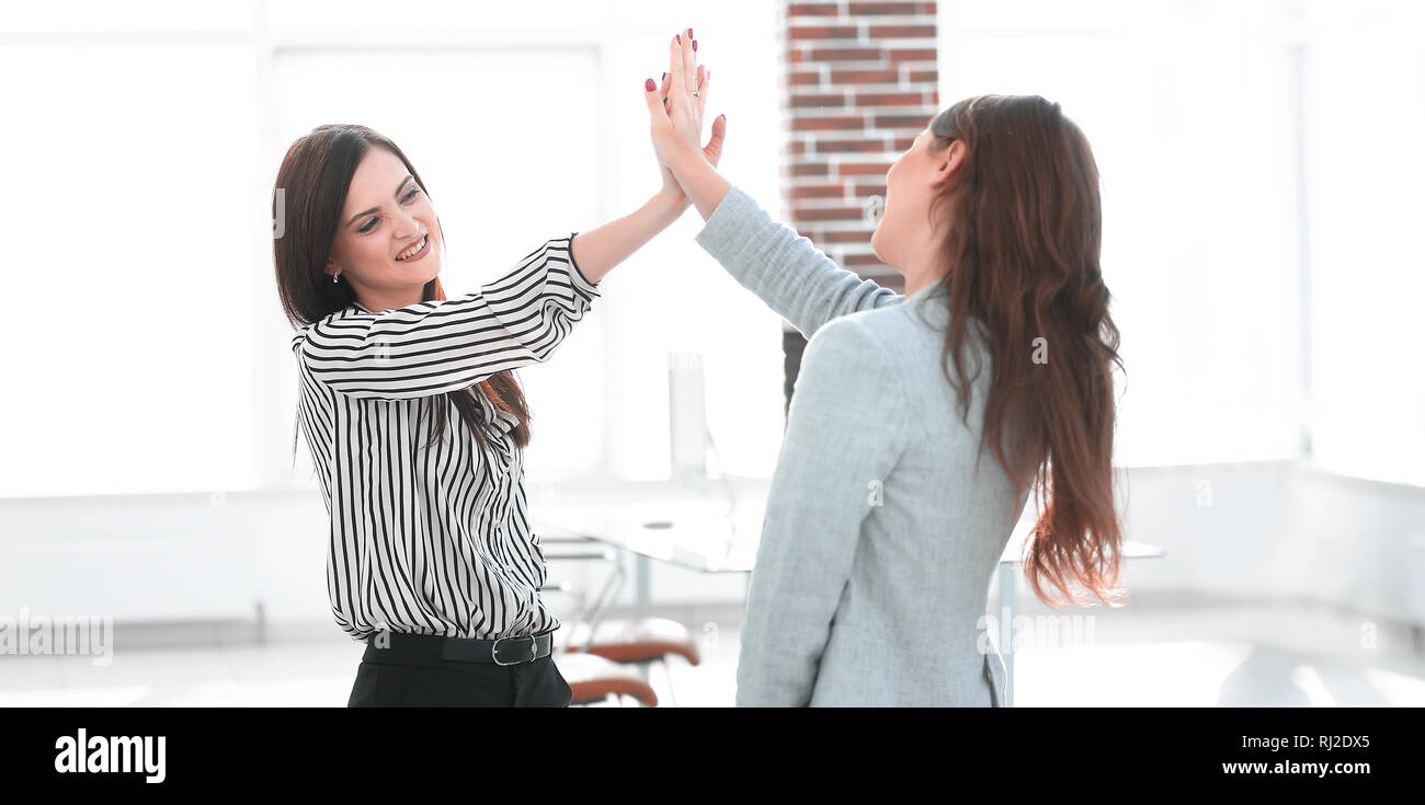 two young co-workers giving each other a high five Stock Photo - Alamy