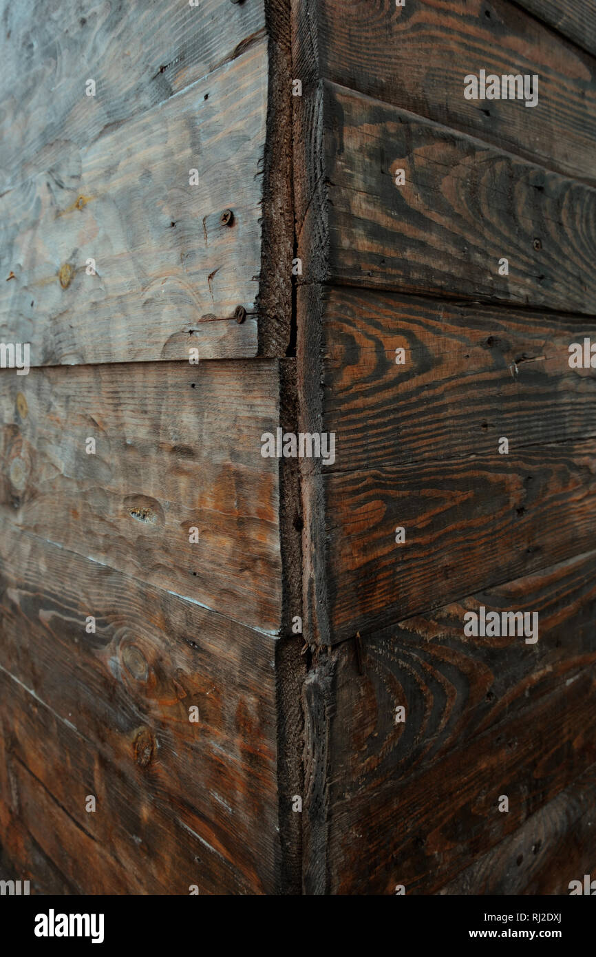 Corner close-up view of a rotten wall made from wood, wooden texture ...