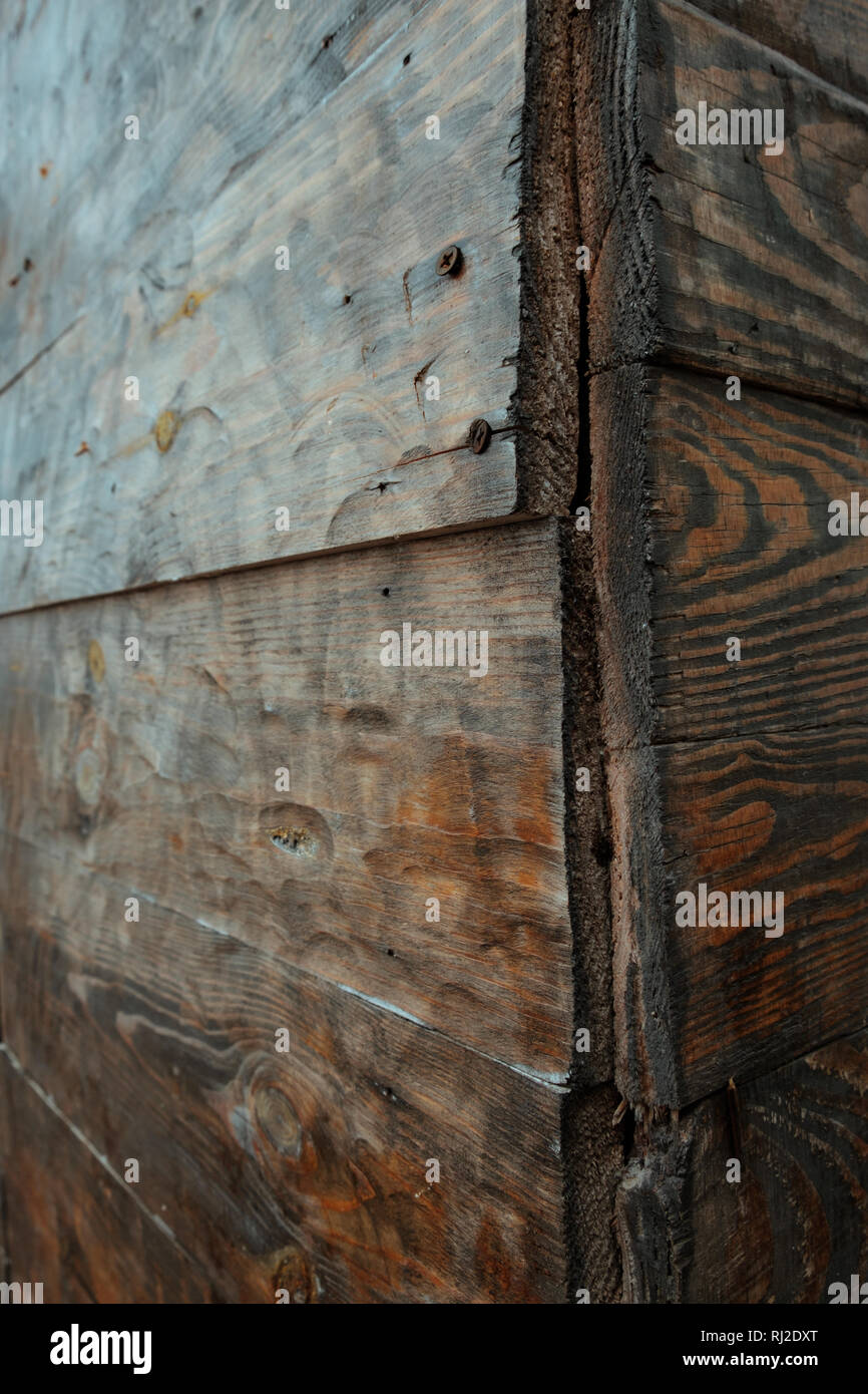 Corner close-up view of a rotten wall made from wood, wooden texture ...