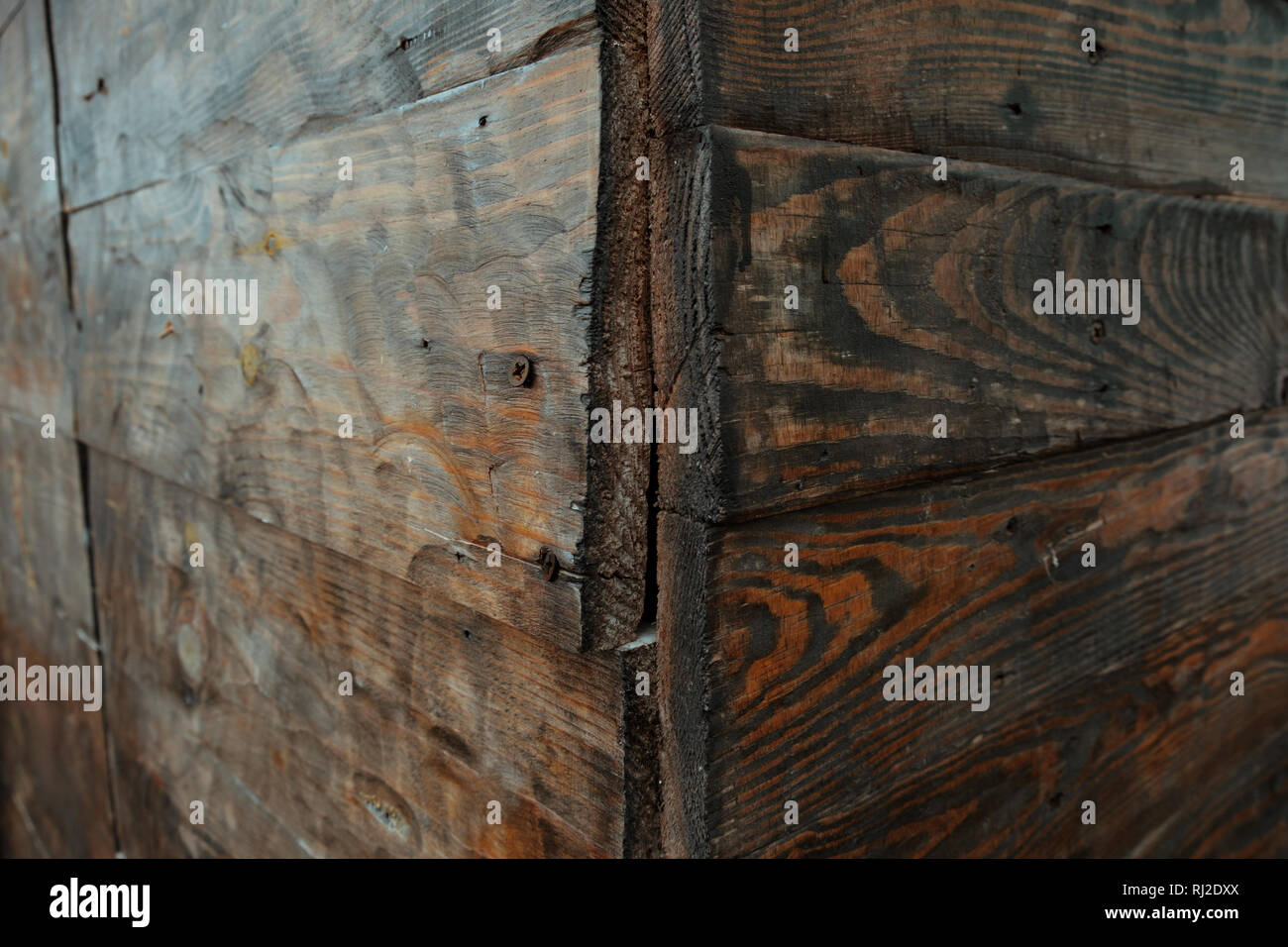 Corner close-up view of a rotten wall made from wood, wooden texture ...