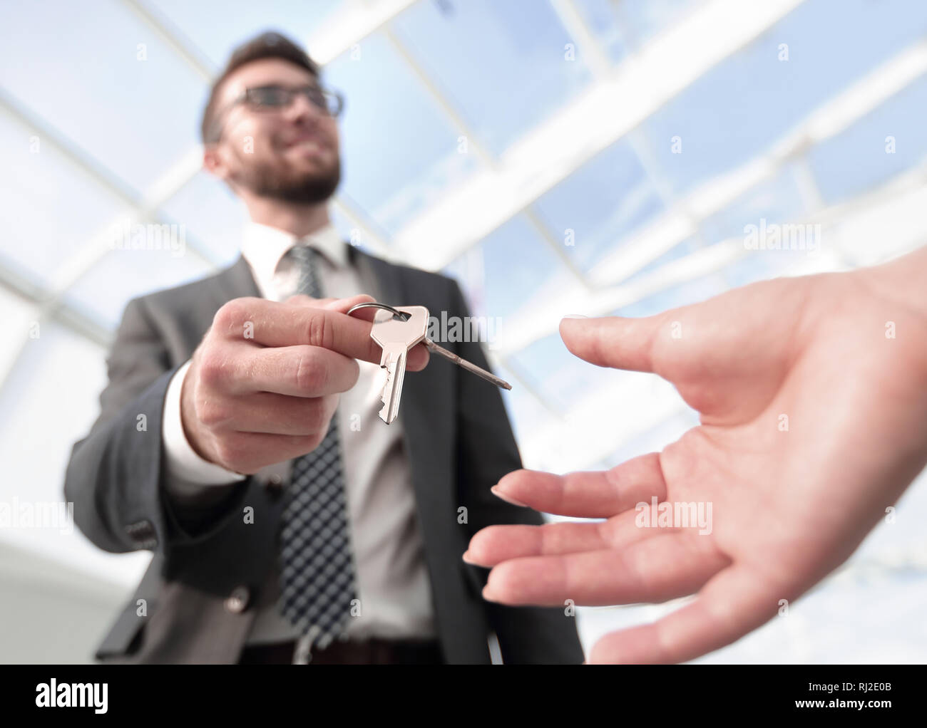 Cropped image of estate agent giving house keys to man in office Stock ...