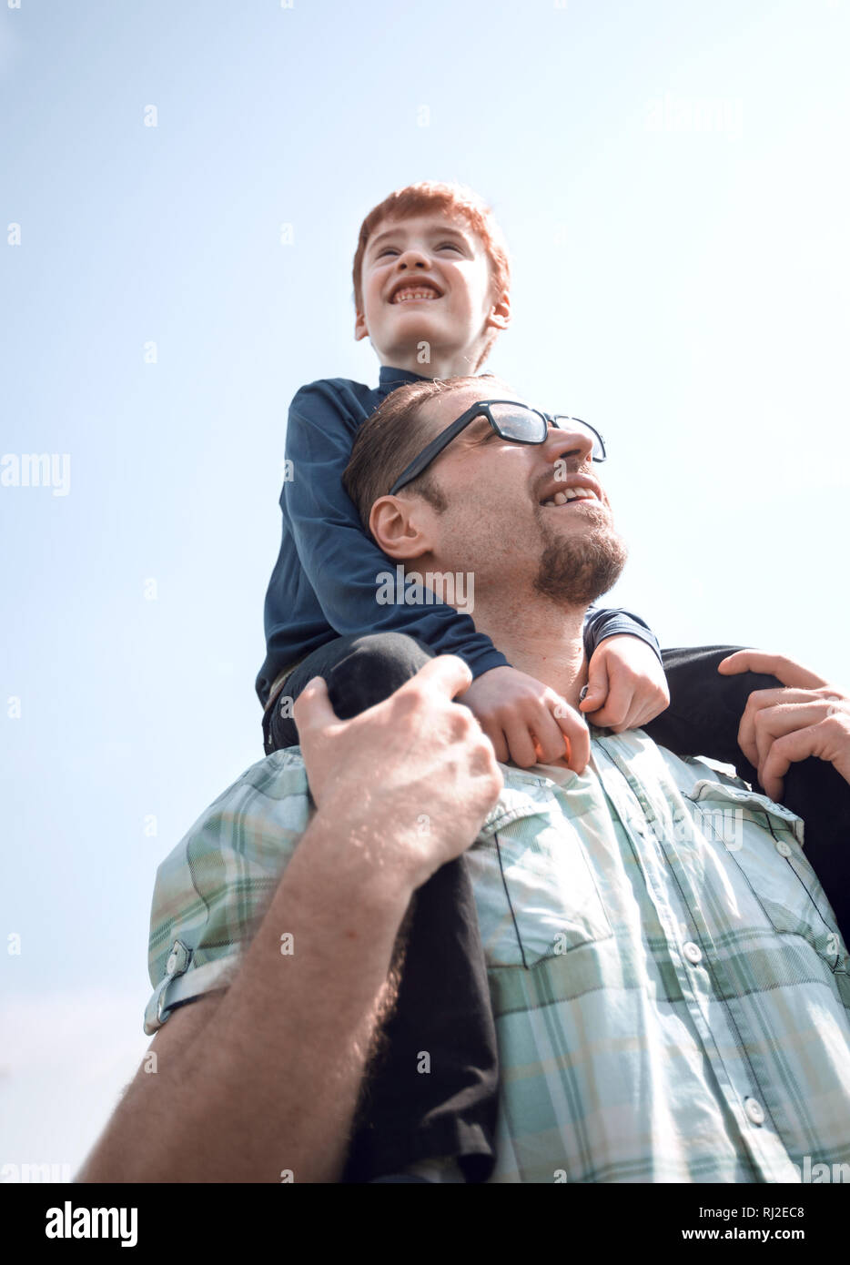 happy son sits on his father's shoulders Stock Photo - Alamy