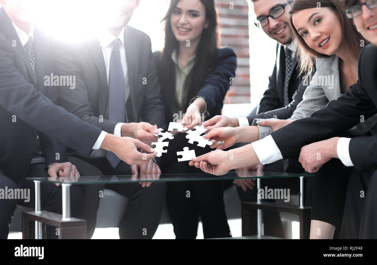 Business team solving puzzle together Stock Photo - Alamy