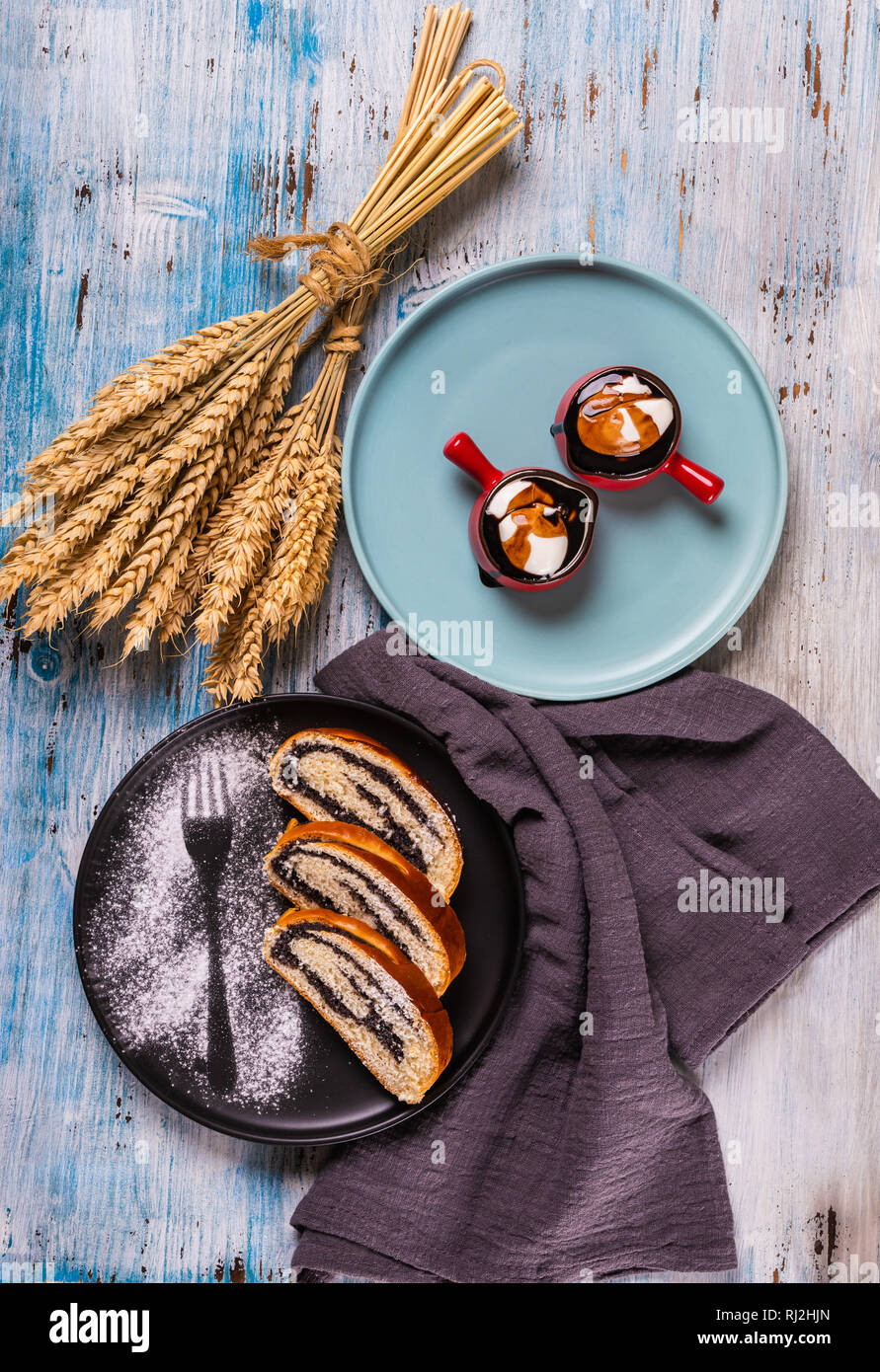 Poppy seed strudel on dark plate with silhouette of fork made by sugar ...