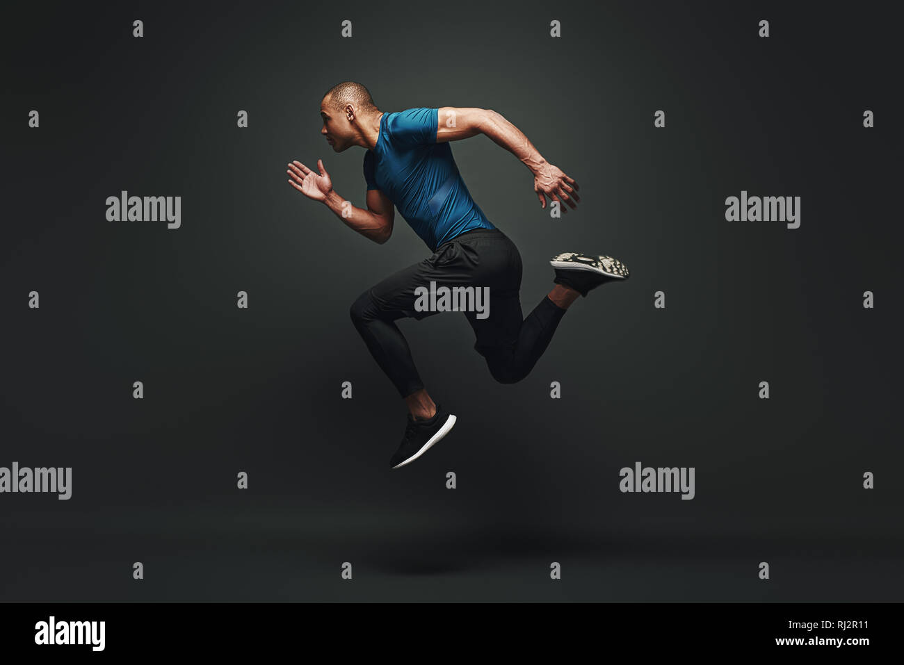 Full length portrait of a healthy muscular sportsman jumping isolated ...