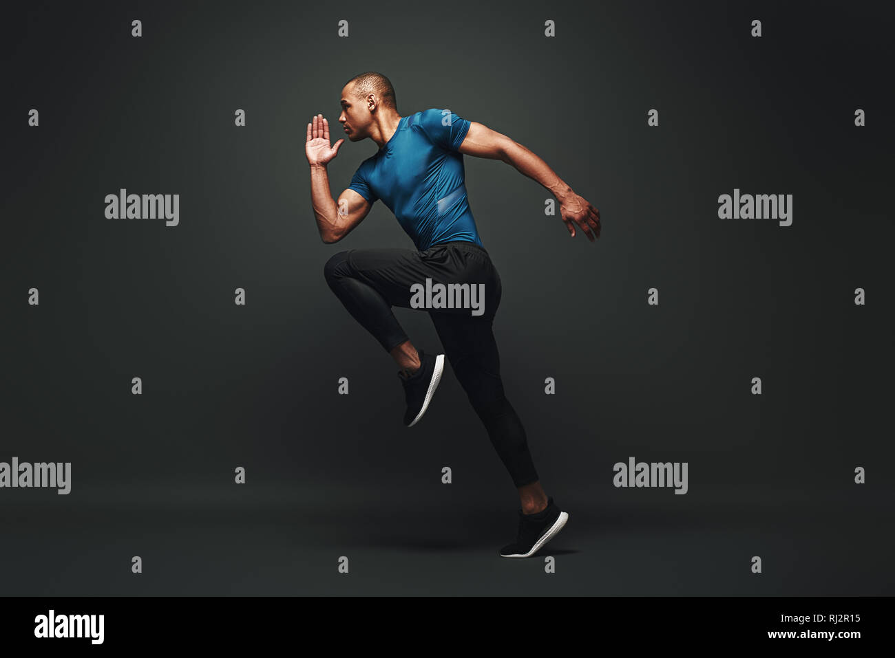 Full length portrait of a healthy muscular sportsman jumping isolated ...