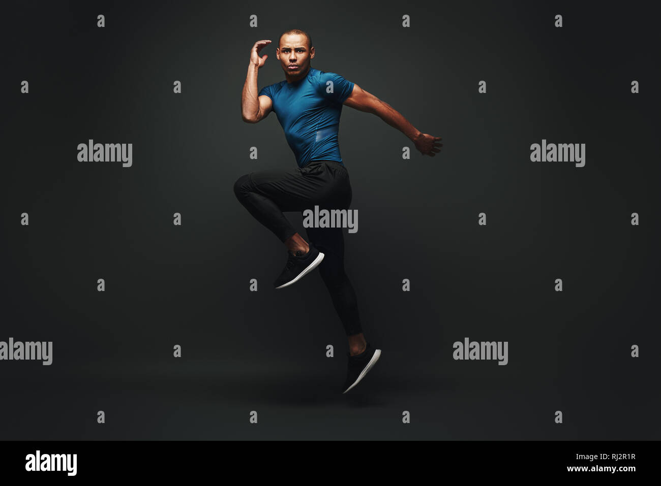 Full length portrait of a healthy muscular sportsman jumping isolated ...