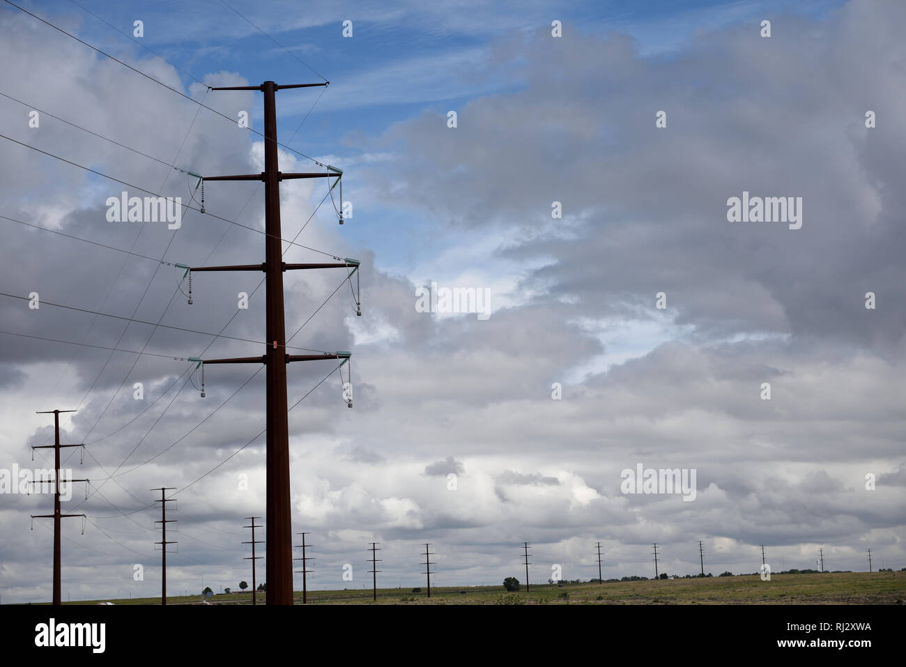 Long row of electricity transmission towers and high voltage power ...