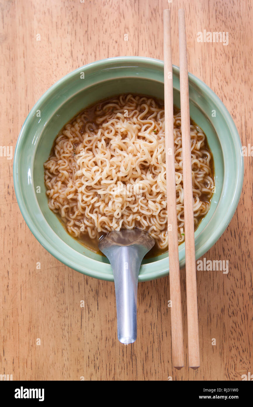 Instant noodle with spoon and chopsticks in a ceramic bowl on wood ...