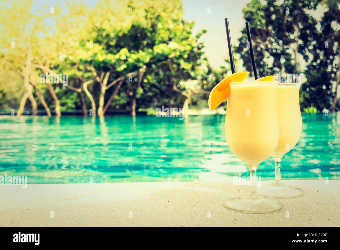 Mango juice with beautiful outdoor swimming pool in hotel resort ...