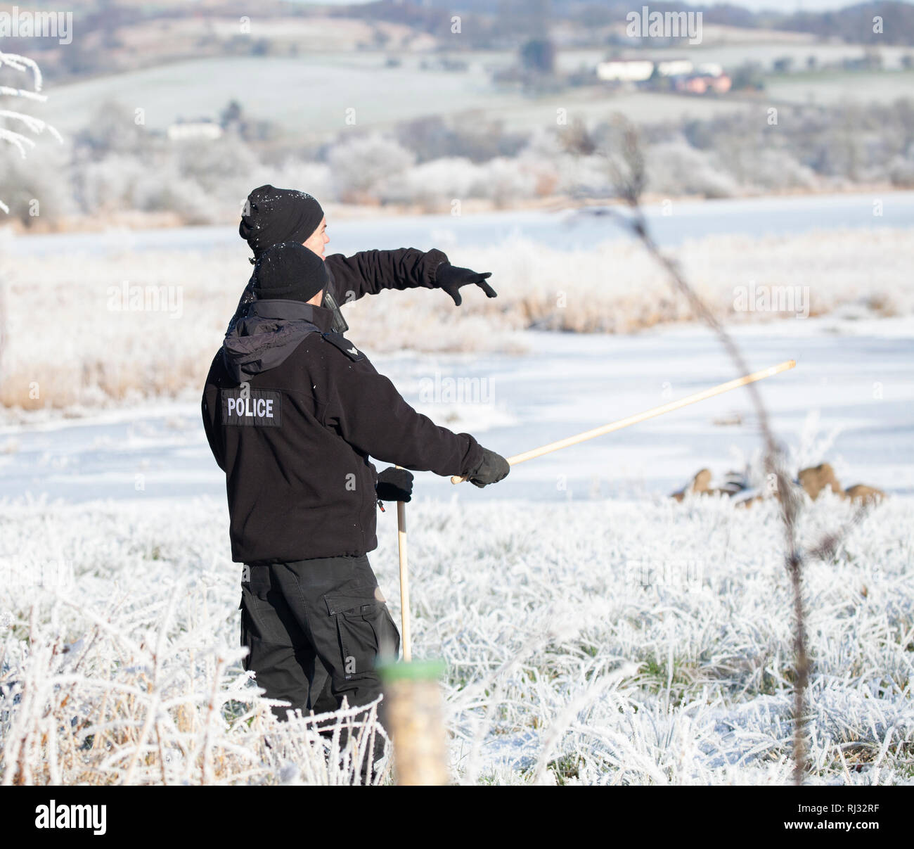 Police officers conducting a missing persons search checking the ...