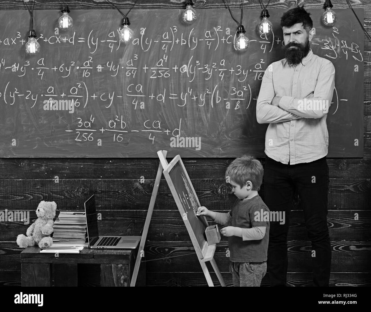Strict math teacher checking pupil s work. Blond schoolboy solving ...