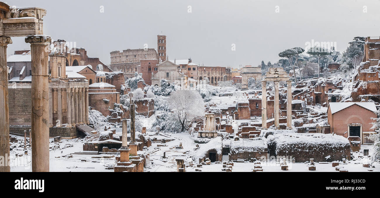 Winter in Rome. Snow falling on Roman Forum ancient ruins and Coliseum ...