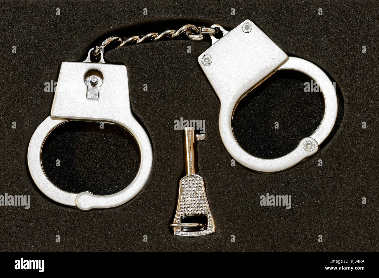 Interesting novelty gift silver handcuffs with key Stock Photo - Alamy