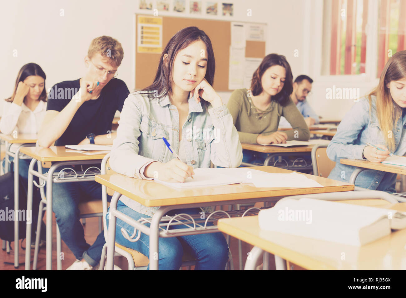 Girl is writing test and answer about task in the classroom Stock Photo ...