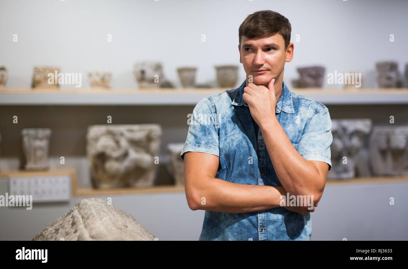 Man looking at exhibits in Ancient Greek hall of historical museum ...
