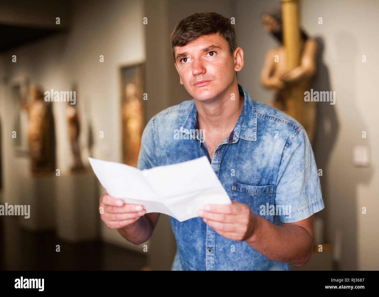 Man visiting historical museum, looking at exhibits and holding ...