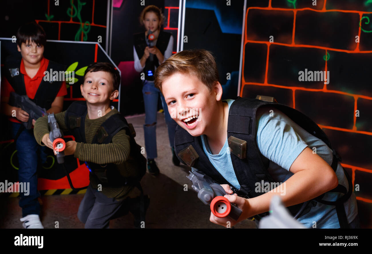 Portrait of happy cheerful preteen boy with laser gun having fun on ...
