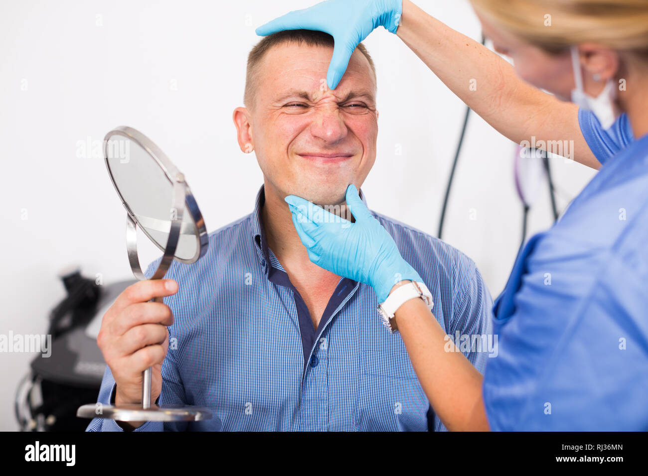 Woman doctor is examining patient behind mirror before the procedure in ...