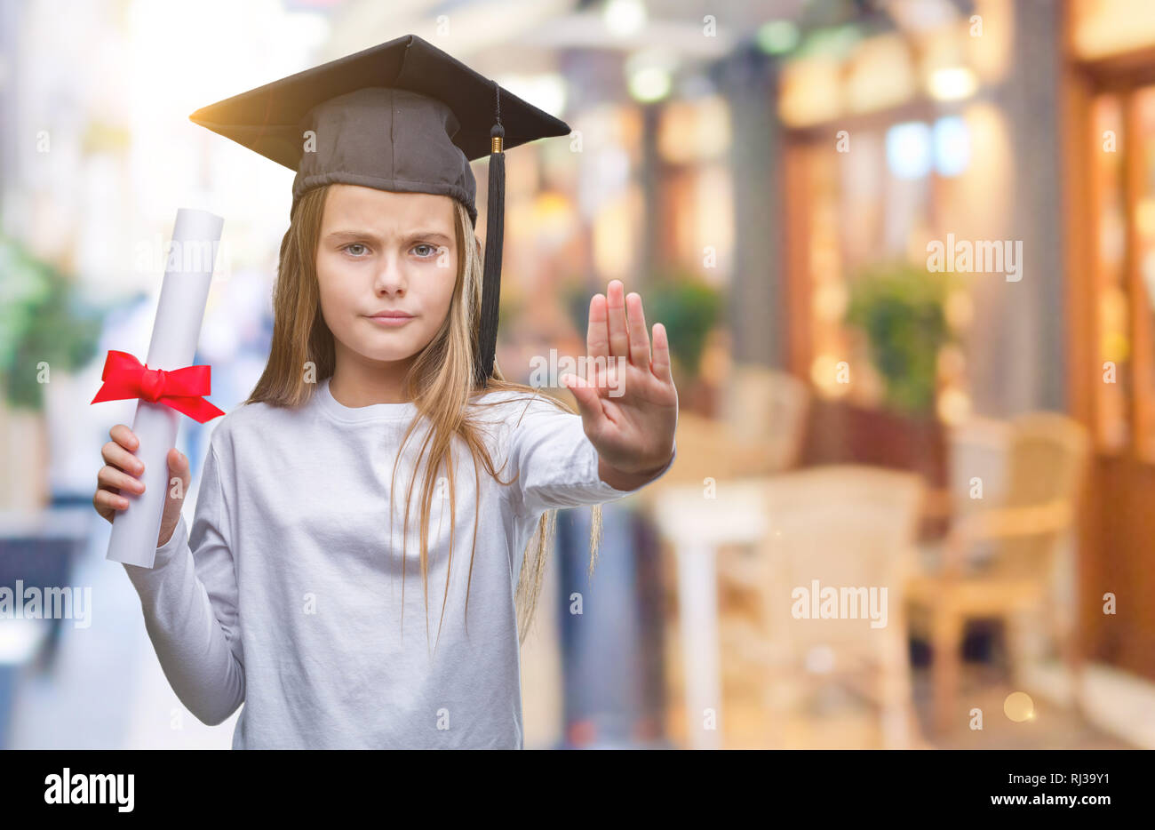 Young beautiful girl wearing graduate cap holding degree over isolated ...