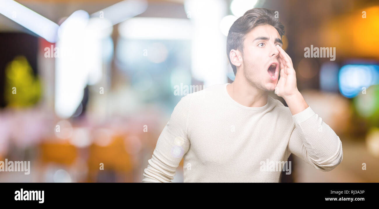 Young handsome man over isolated background shouting and screaming loud ...