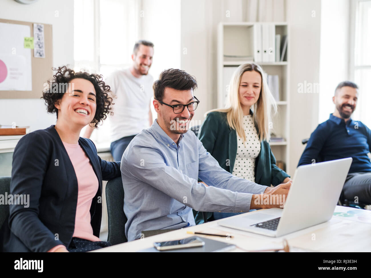 Group of young businesspeople around table in a modern office, having ...