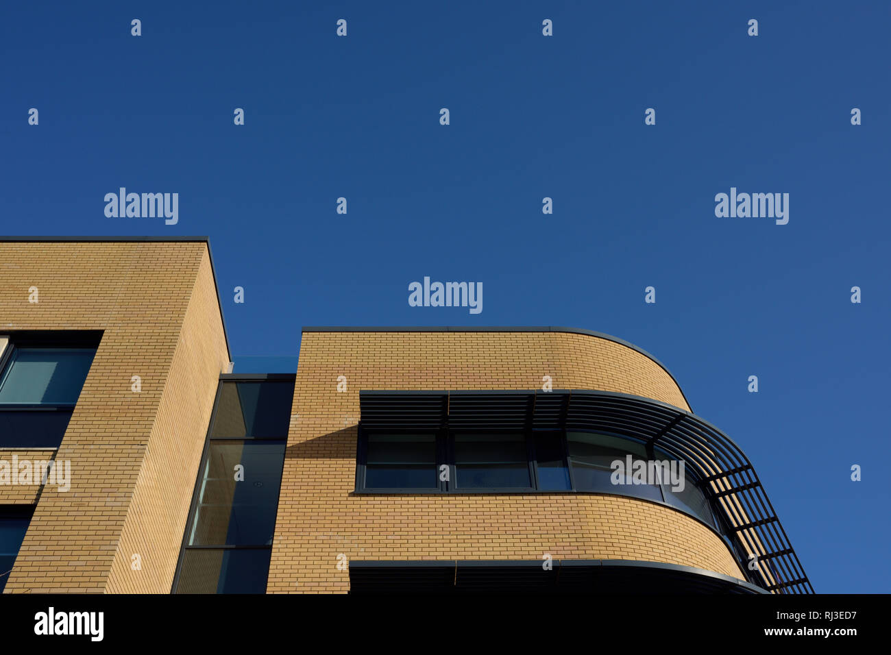 Modern building with curved facade, buff brickwork and curved ribbon ...