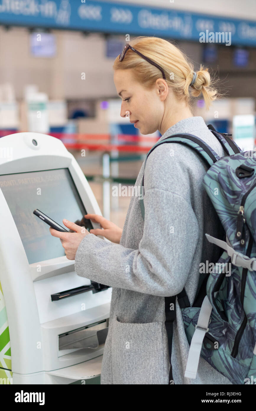 Casual caucasian woman using smart phone application and check-in ...