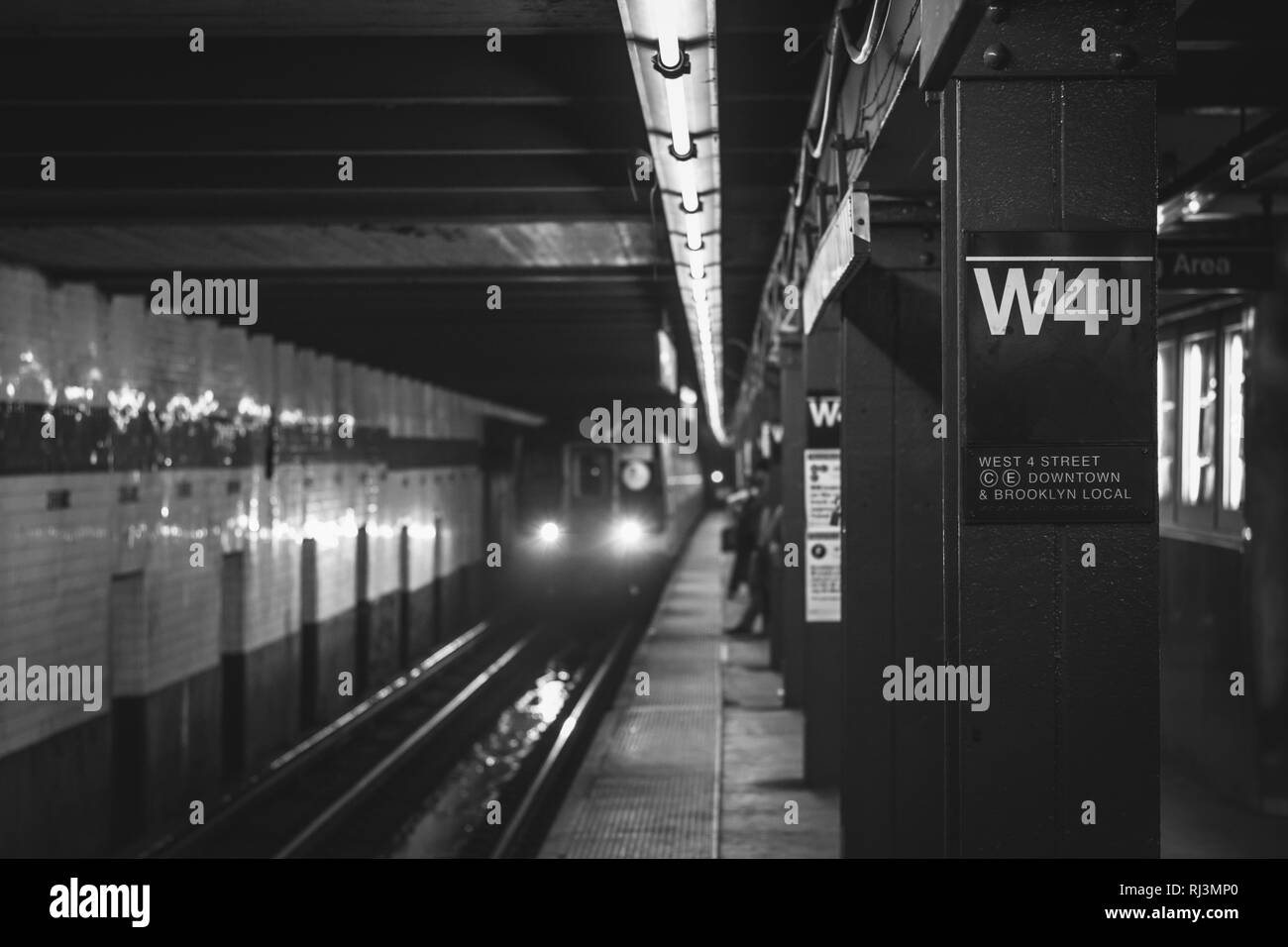 A train approaching the platform at West 4th Street subway station in Manhattan, New York City ...